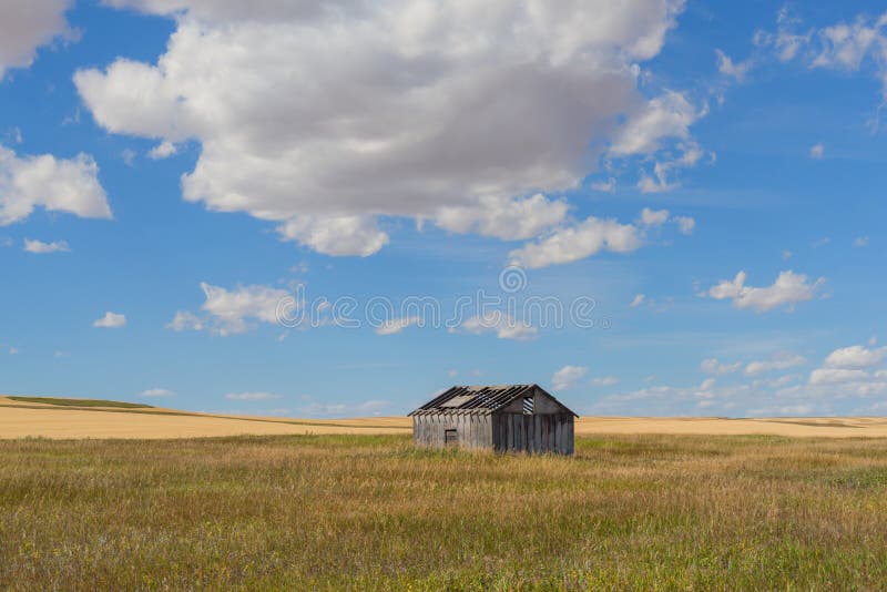 Old Abandoned Farm Building in the Prairie with a Cloudy Blue Sky Stock ...