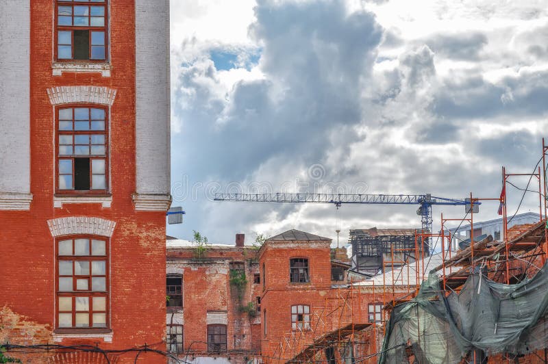 An Old Abandoned Red Brick Building with Broken Windows on the ...