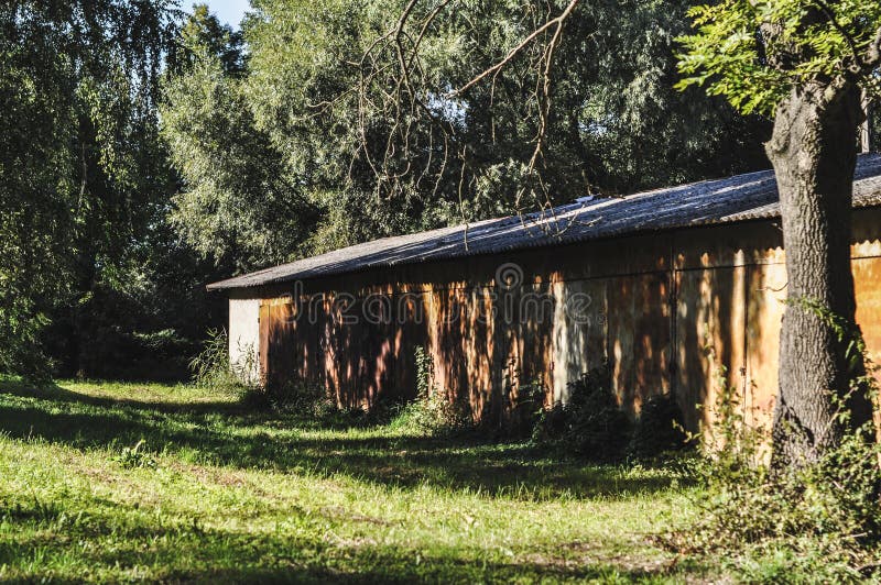 Old Abandoned Rusty Warehouse Buildings Amidst Greenery and Sunlight ...