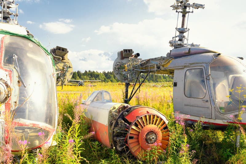 Old Airplane Fuselage and Rusty Helicopters on Green Grass Stock Photo ...