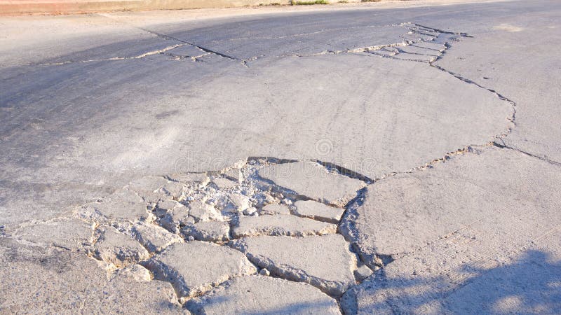 The Old Badly Damaged Curve Concrete Street with Broken Crack Lines and ...