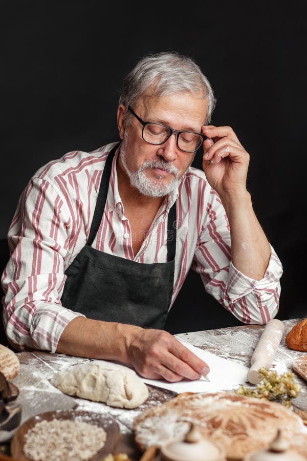 Old Baker Writing Down Old-time Recipe in Bakery Notebook Surrounded by ...