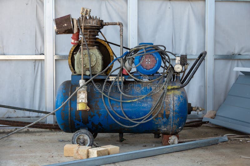 An Old Blue Working Mobile Air Compressor for Painting Walls on a ...
