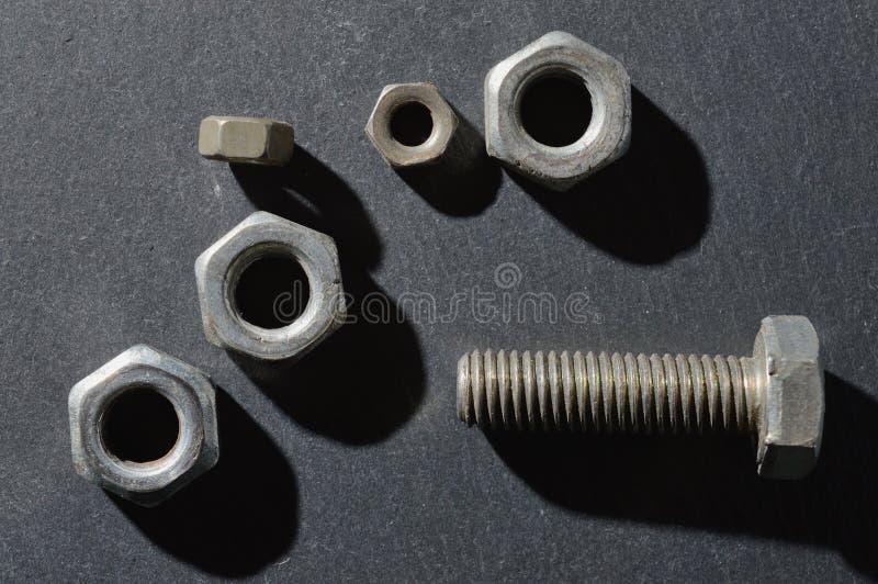 Bolts and Nuts of Different Sizes Lie on a White Background. Top View ...