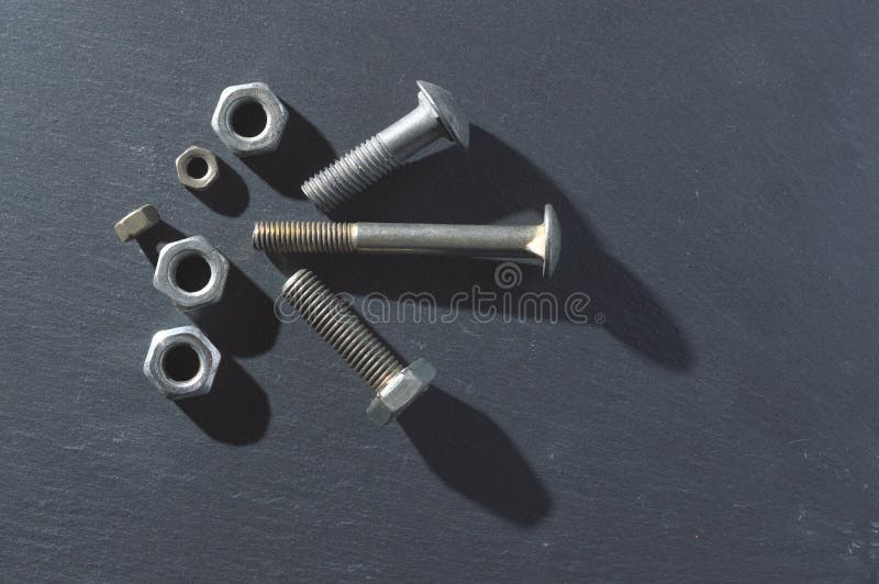Bolts and Nuts of Different Sizes Lie on a White Background. Top View ...