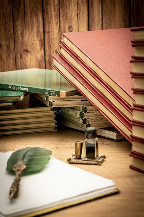 Old Books Stacked in Disarray, an Old Pen with Its Ink and a Notepad on ...