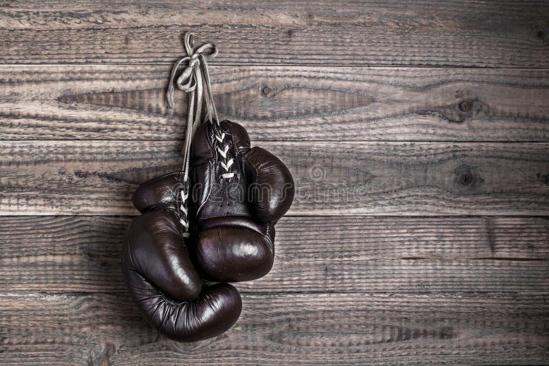 Old Boxing Gloves Hanging in Front of Rustic Wooden Wall Stock Photo ...