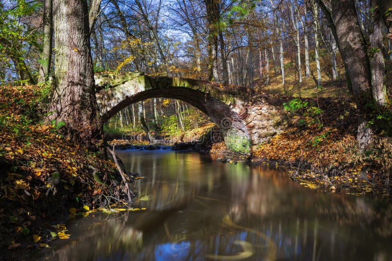 An Old Bridge Over a River Built in a Deciduous Forest. Autumn and ...