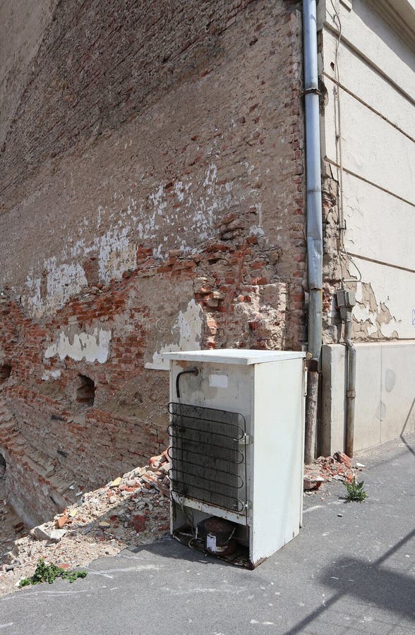 Old Broken Fridge on the Street Next To a House Under Demolition Stock ...