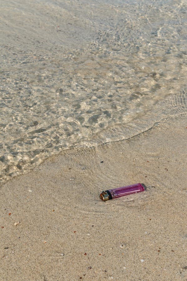 An Old and Broken Lighter Polluting the Beach Stock Photo - Image of ...