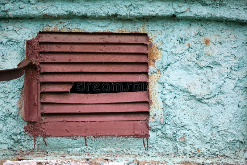 Old Brown Metal Grating with a Broken Compartment in a Concrete Wall ...