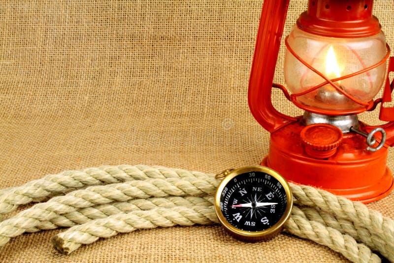 Old Burning Oil Lamp, Compass, and Rope on Burlap Stock Image - Image ...