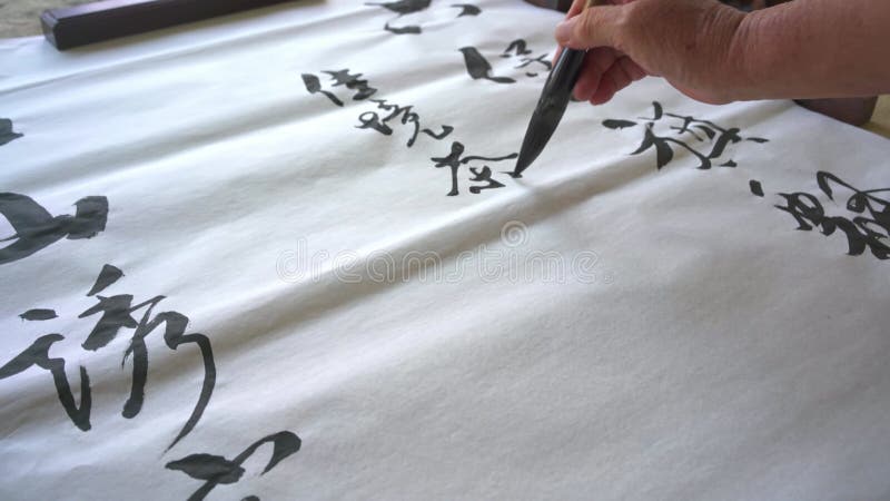 An Old Calligrapher is Writing Calligraphy Characters, Creating ...