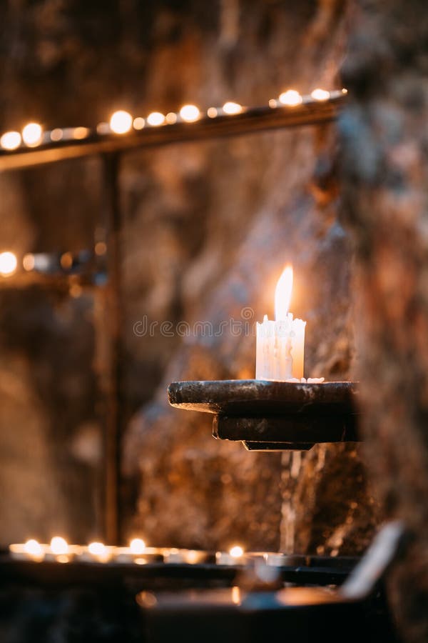 Old Candle in Church. Candle Light Flame Near Ancient Wall Stock Image ...