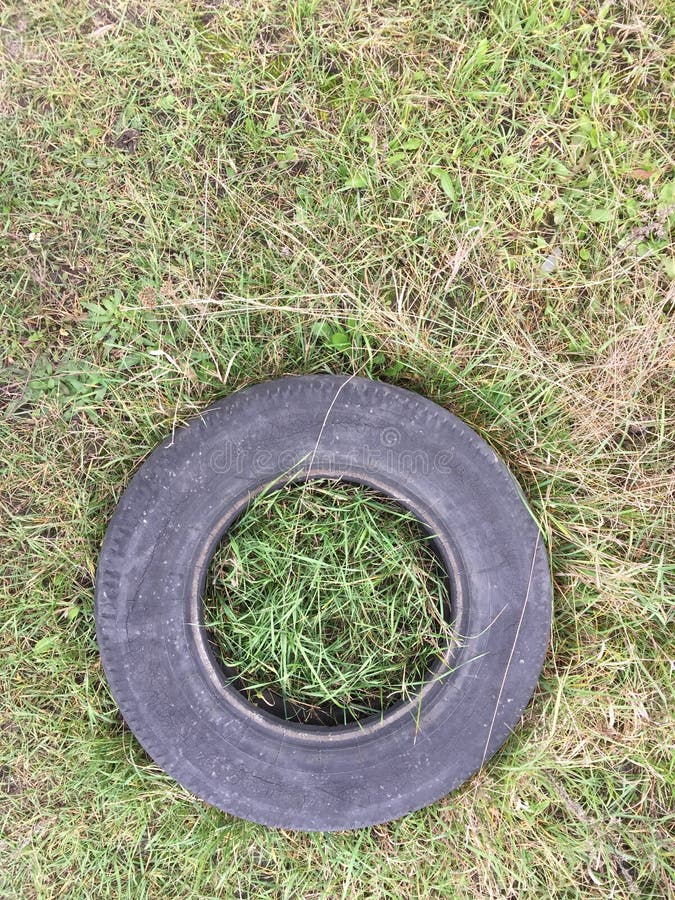Old tire in grass stock photo. Image of dirty, vehicle - 41660814