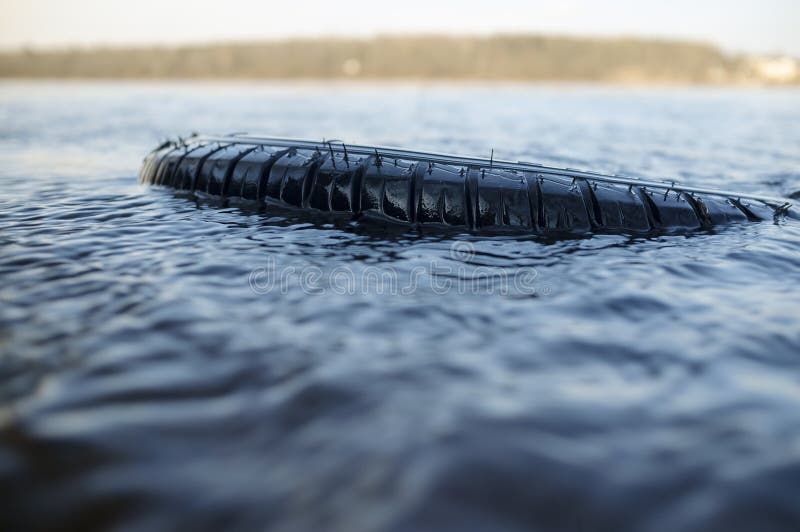 Old Car Tire Thrown into the River. Concept of Environmental Pollution ...