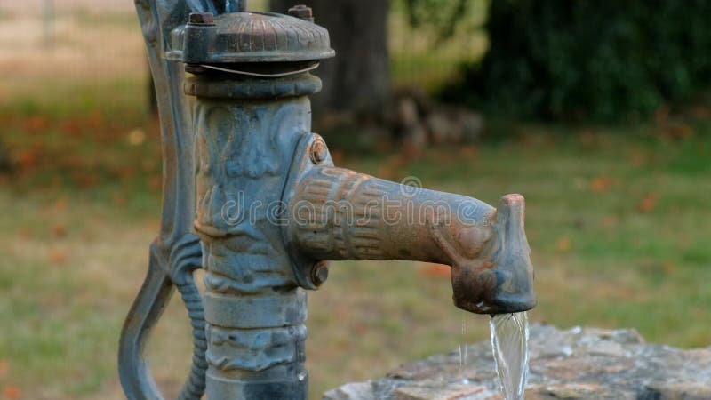 An Old Cast-iron Hand Pump Column with Flowing Water in Close-up Stock ...