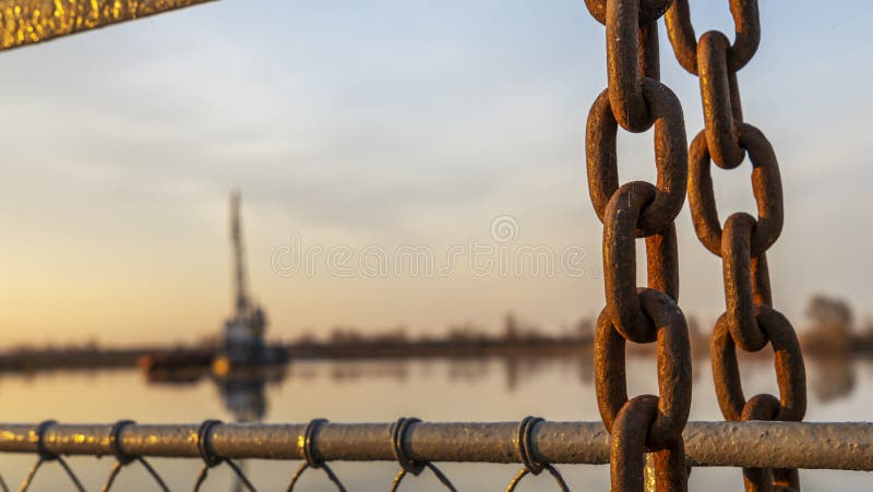 The Old Chain by the Pier at Sunset. Defocused Background with Ship and ...