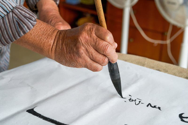 An Old Chinese Calligrapher is Writing Calligraphy Characters, Creating ...