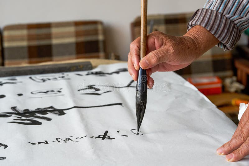 An Old Chinese Calligrapher is Writing Calligraphy Characters, Creating ...