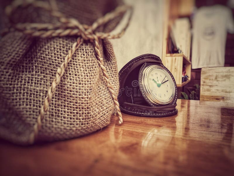 The Old Clock and the Green Grass are on a Wooden Table with a Walled ...