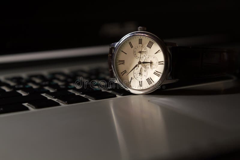An Old Clock and a Laptop , the Clock is on the Laptop Keyboard. Watch ...