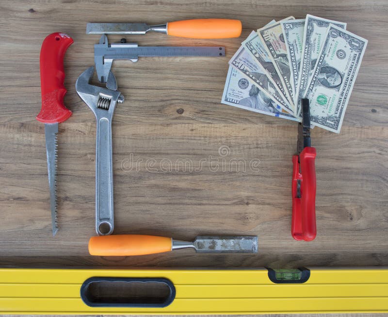 Old Construction Tools and a Set of Dollar Bills on a Wooden Table ...