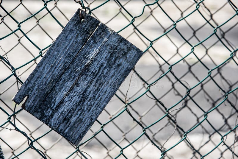 Old Cracked Rectangular Wooden Plate on an Old Green Mesh Fence Stock ...