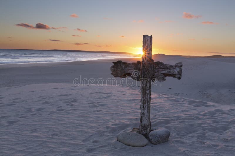 An Old Cross on Sand Dune Next To the Ocean with a Calm Sunrise Stock ...