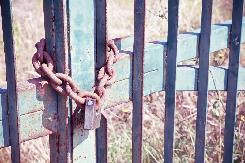 Old Damaged and Rusty Metal Gate of a Factory Closed with Padlock Stock ...