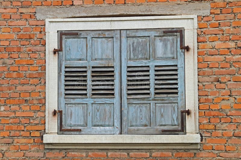 Old and Dilapidated Shutters on a Brick Building with White Surrounds ...