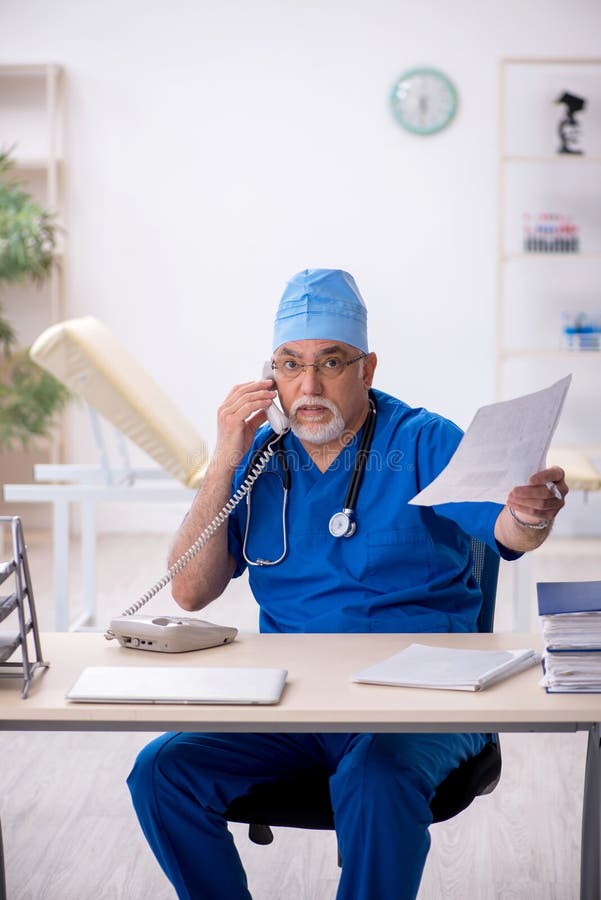 Old Male Doctor Working in the Clinic Stock Image - Image of remote ...