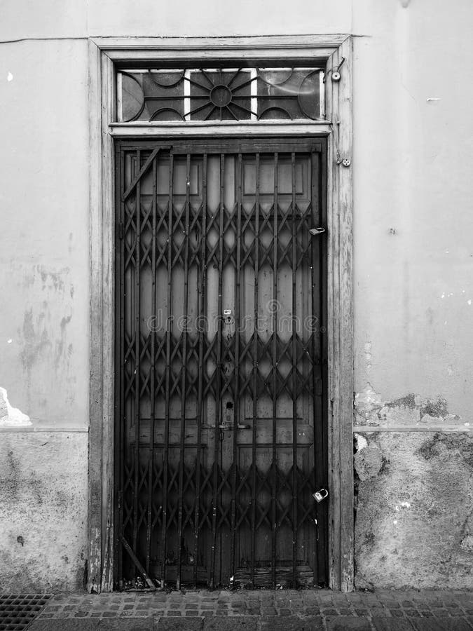 Old Doors with Black Iron Security Gate on a Shabby Wall Stock Photo ...