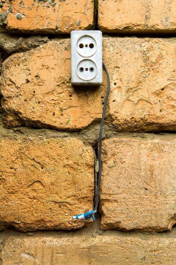 An Old Electrical Outlet with Dangling Wire on a Brick Wall. Stock ...