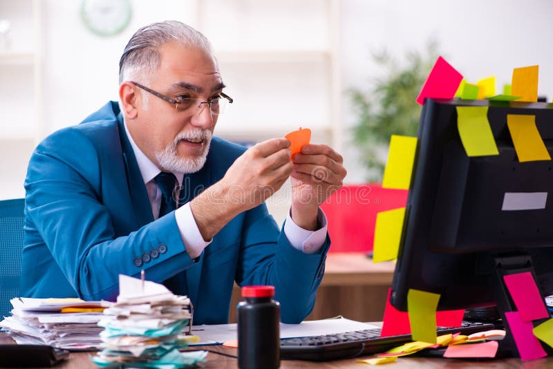 Old Employee Working in the Office in Conflicting Priorities Stock ...