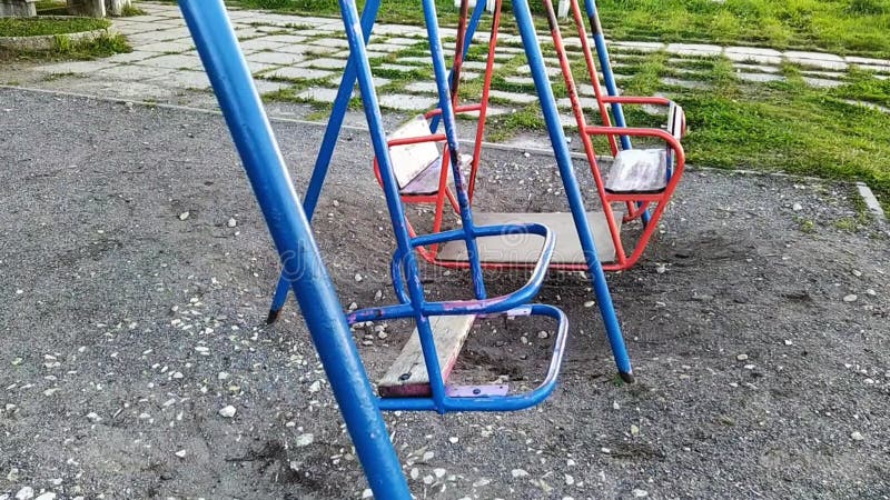 Old and Empty Swings Move from Side To Side on the Playground during ...
