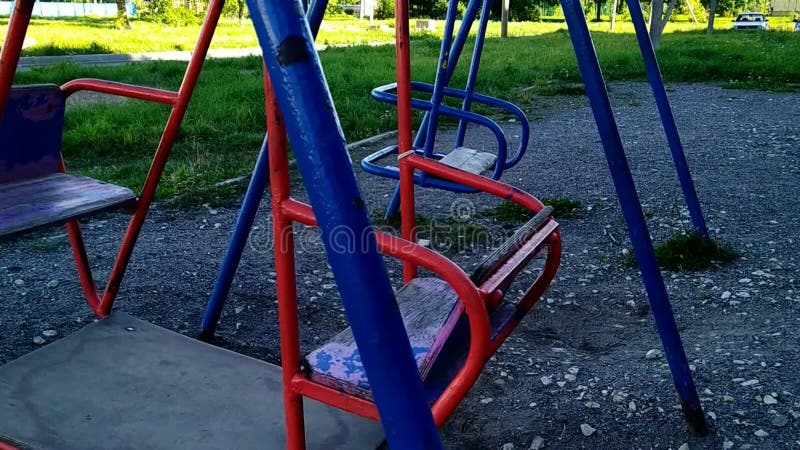 Old and Empty Swings Move from Side To Side on the Playground during ...