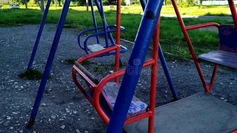 Old and Empty Swings Move from Side To Side on the Playground during ...