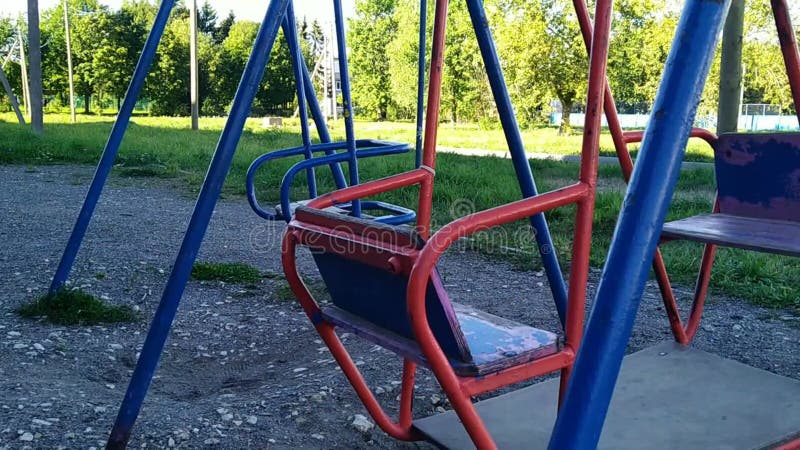 Old and Empty Swings Move from Side To Side on the Playground during ...