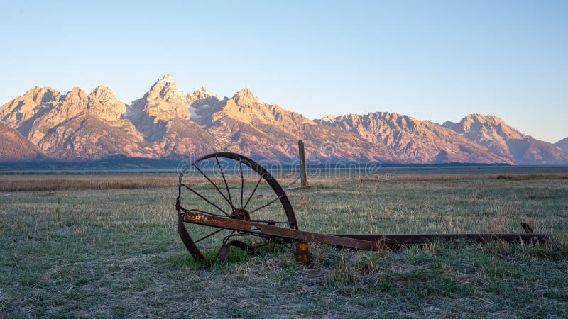 Old Farm Equipment on a Flat Plain in Front of the Teton Mountain Range ...