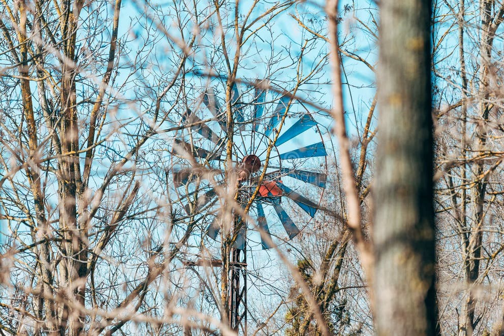 Old Farm Windmill Turbine Seen through Bare Tree Branches Stock Image ...