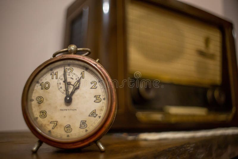 An Old Fashioned Clock Sits on a Shelf in Front of a Television ...
