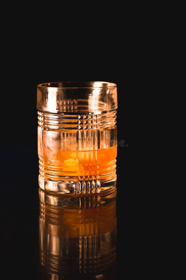 Old Fashioned Cocktail in a Rocks Glass on a Black Reflective Surface ...