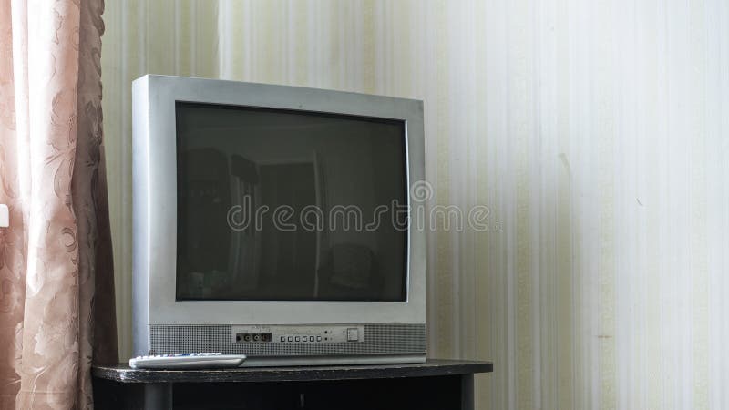 Old-fashioned CRT Television Set Sits on Dark Table in Room with ...