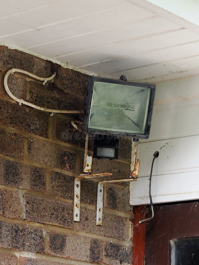 An Old Fashioned Home Security Light Mounted Under the Eaves on a Brick ...