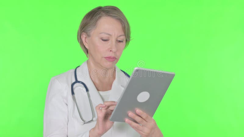Old Female Doctor Using Digital Tablet on Green Background Stock Photo ...