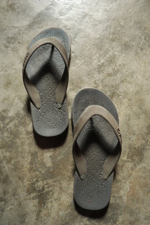 A Pair of Sandals in a Dull Gray Color Were Old on the Plain Floor ...
