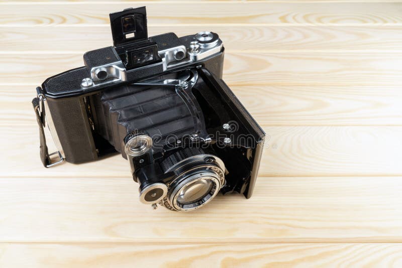 Old Folding Camera on a Textured Rustic Wooden Surface. Stock Image ...