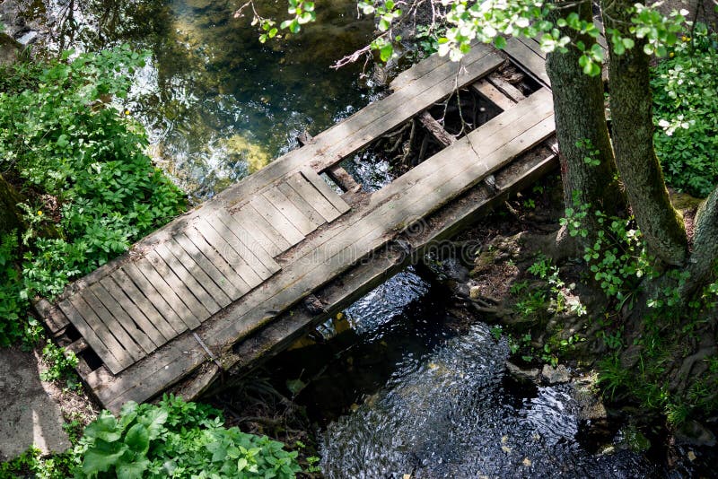 Old Footbridge Over a Running Stream with Holes in the Deck Stock Image ...