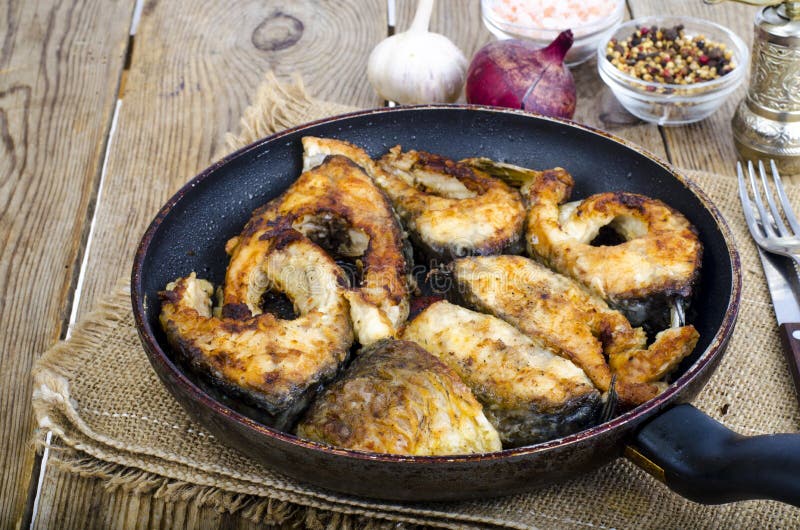 Old Frying Pan with Fried Fish on Wooden Table. Stock Image - Image of ...